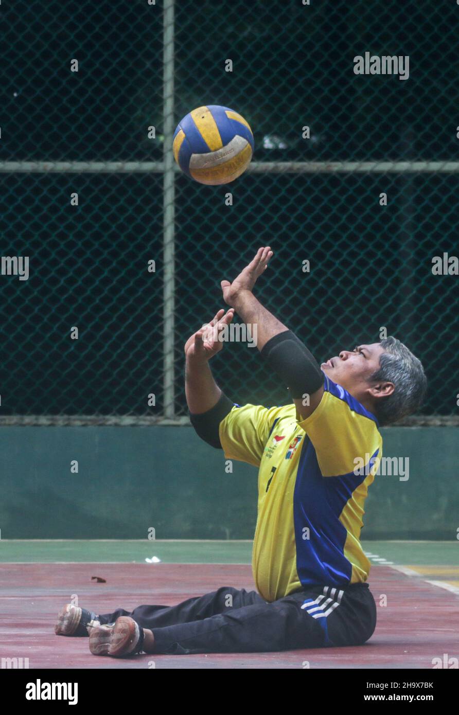 athletes with disabilities practice sitting volleyball on the indoor ...