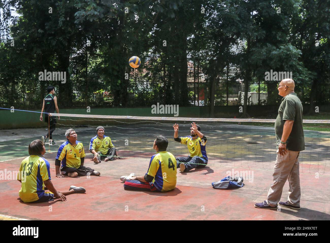 athletes with disabilities practice sitting volleyball on the indoor ...