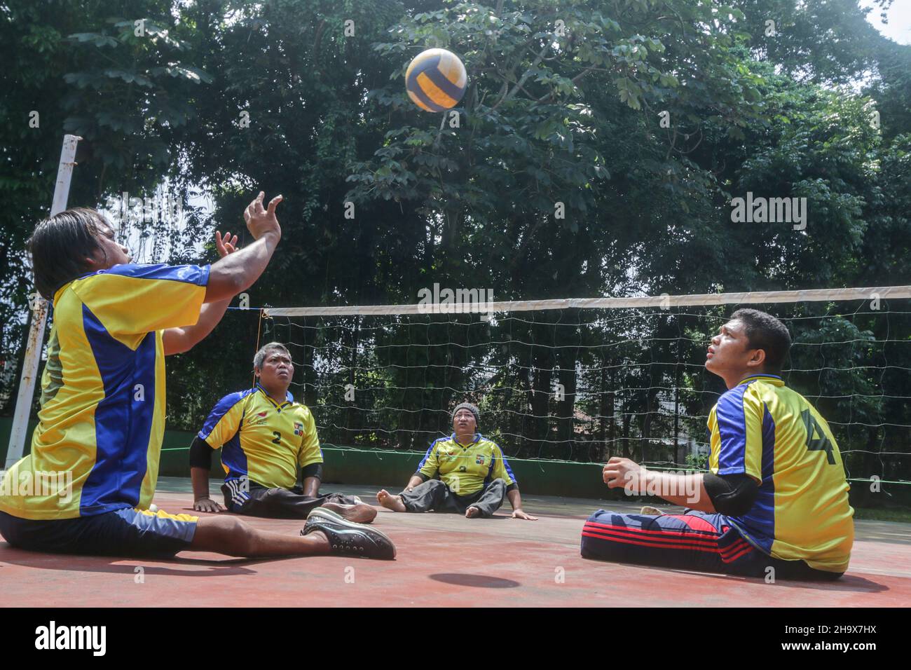 athletes with disabilities practice sitting volleyball on the indoor ...
