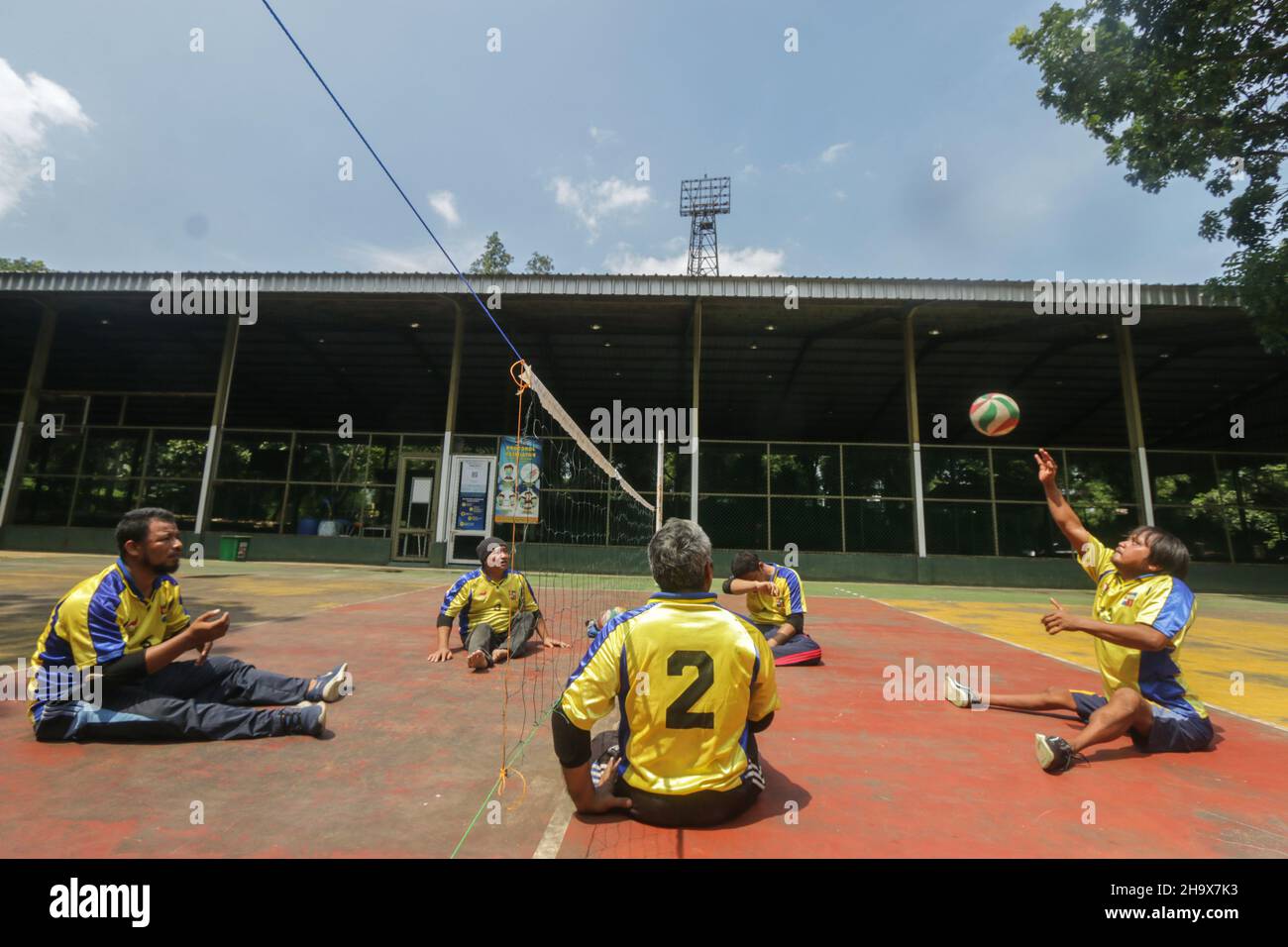 athletes with disabilities practice sitting volleyball on the indoor ...