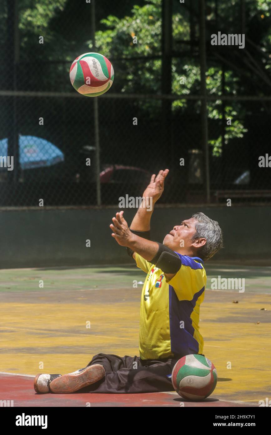 athletes with disabilities practice sitting volleyball on the indoor ...