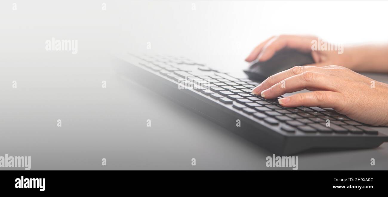 Hands typing on a remote wireless computer keyboard in the office at ...