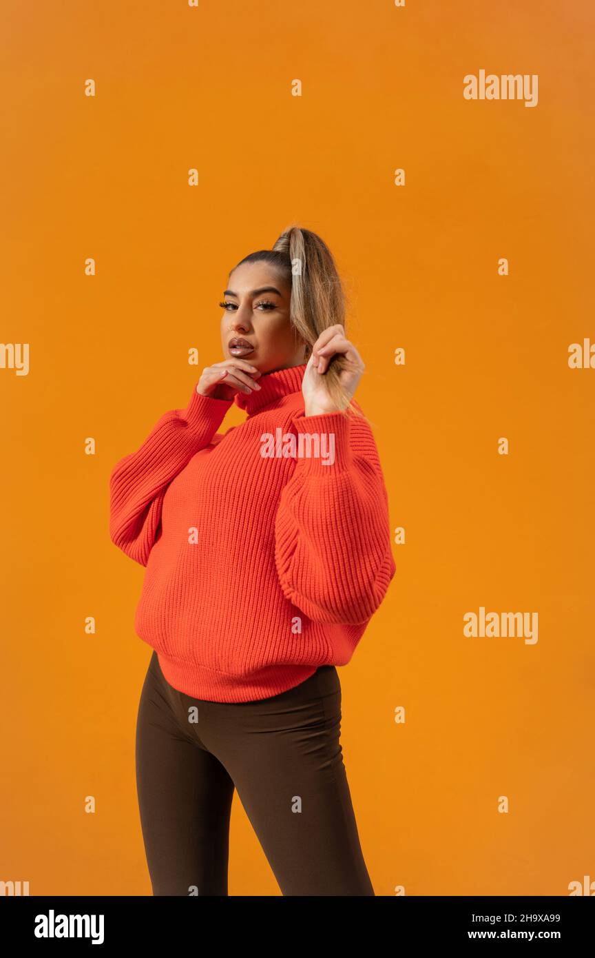 Fancy Spanish model in a bright casual outfit is standing in the bright ...