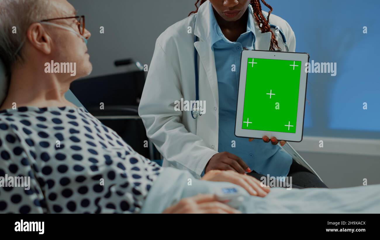 Surgeon woman holding green screen tablet in hospital ward to show sick ...