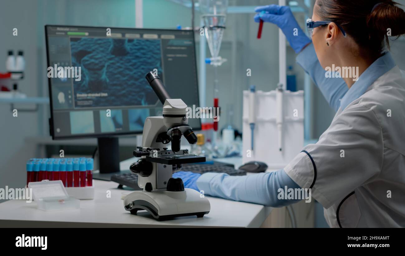 Biochemistry doctor analyzing vacutainer with blood while having ...