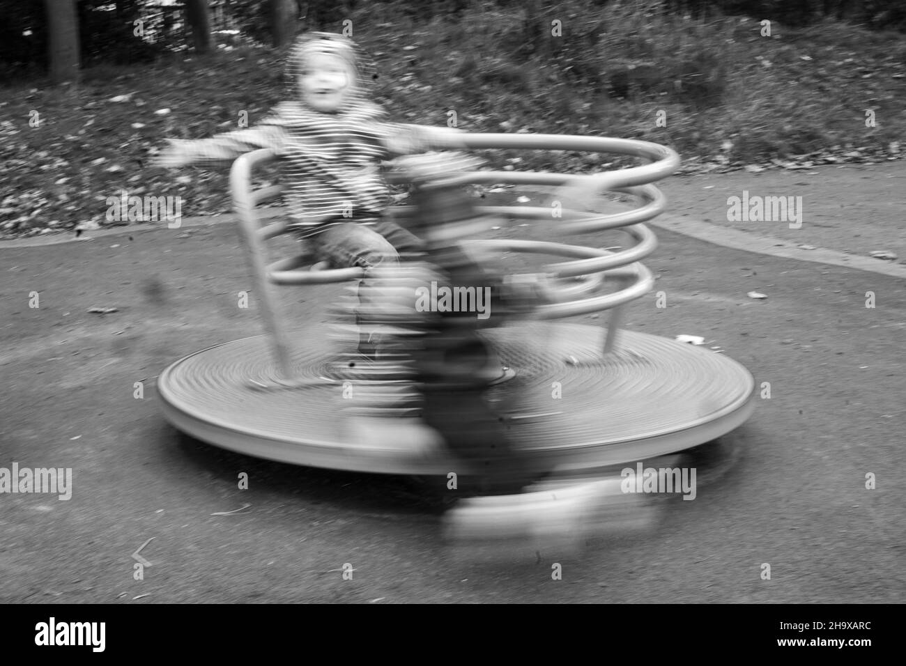 Children at play on roundabout Stock Photo - Alamy