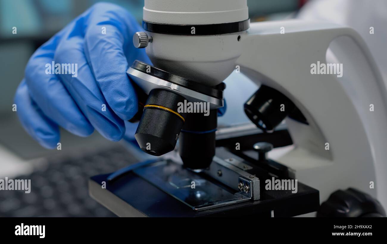 Close up of optical lens from microscope in science laboratory. Hands ...