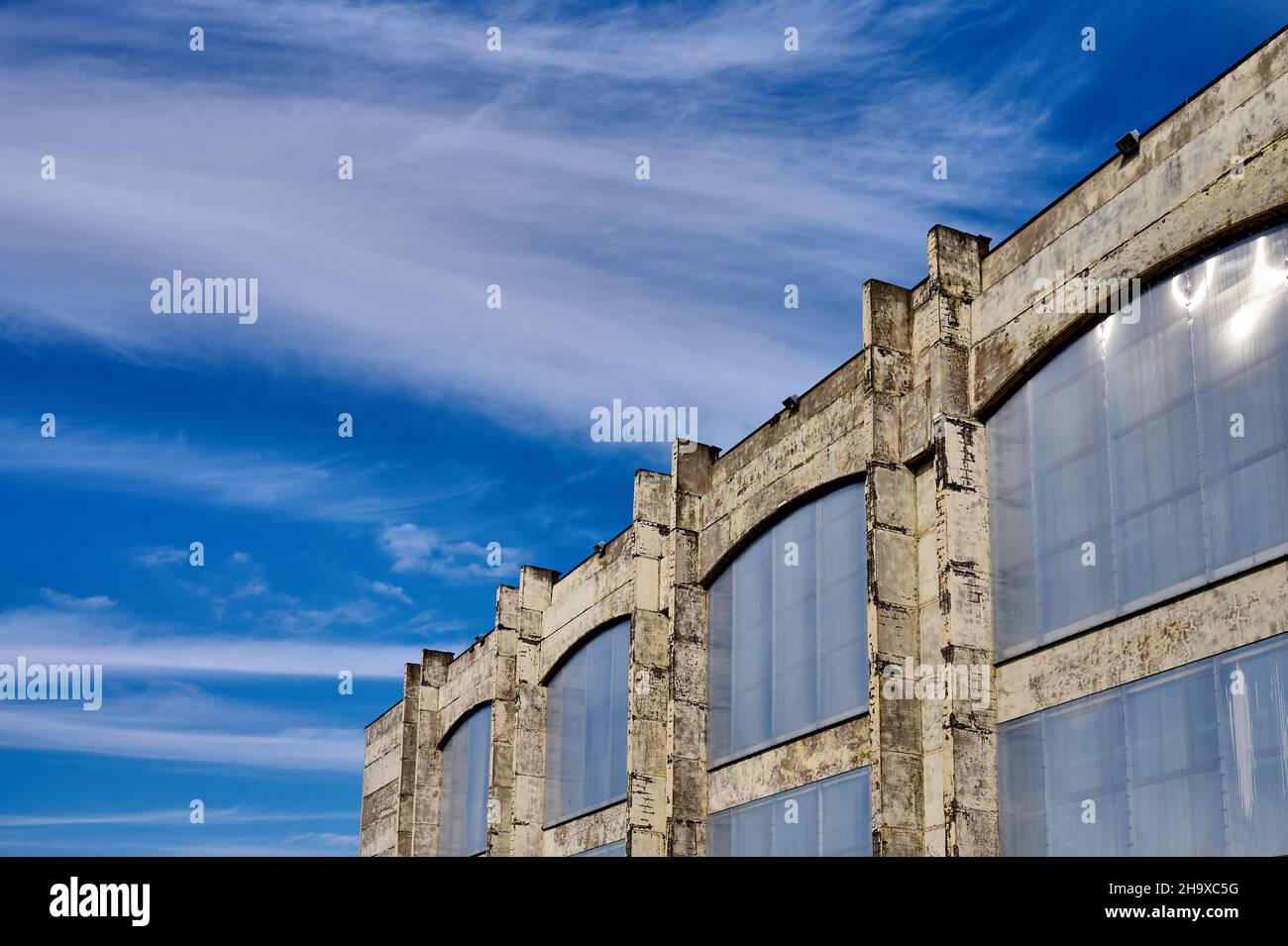 Building of the old abandoned production hall with windows closed with ...