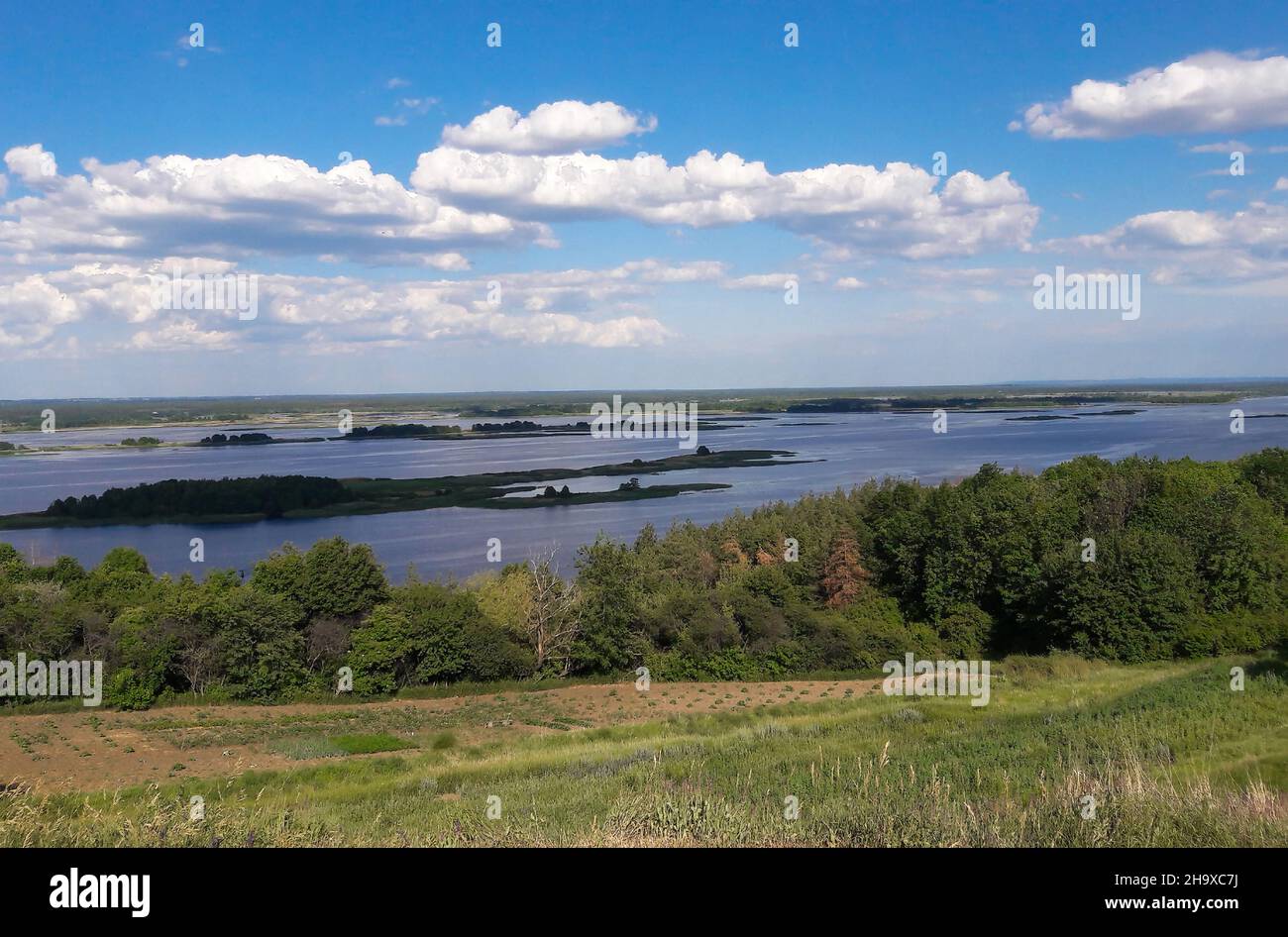 Below, under the hill, there is a wide river against the background of ...