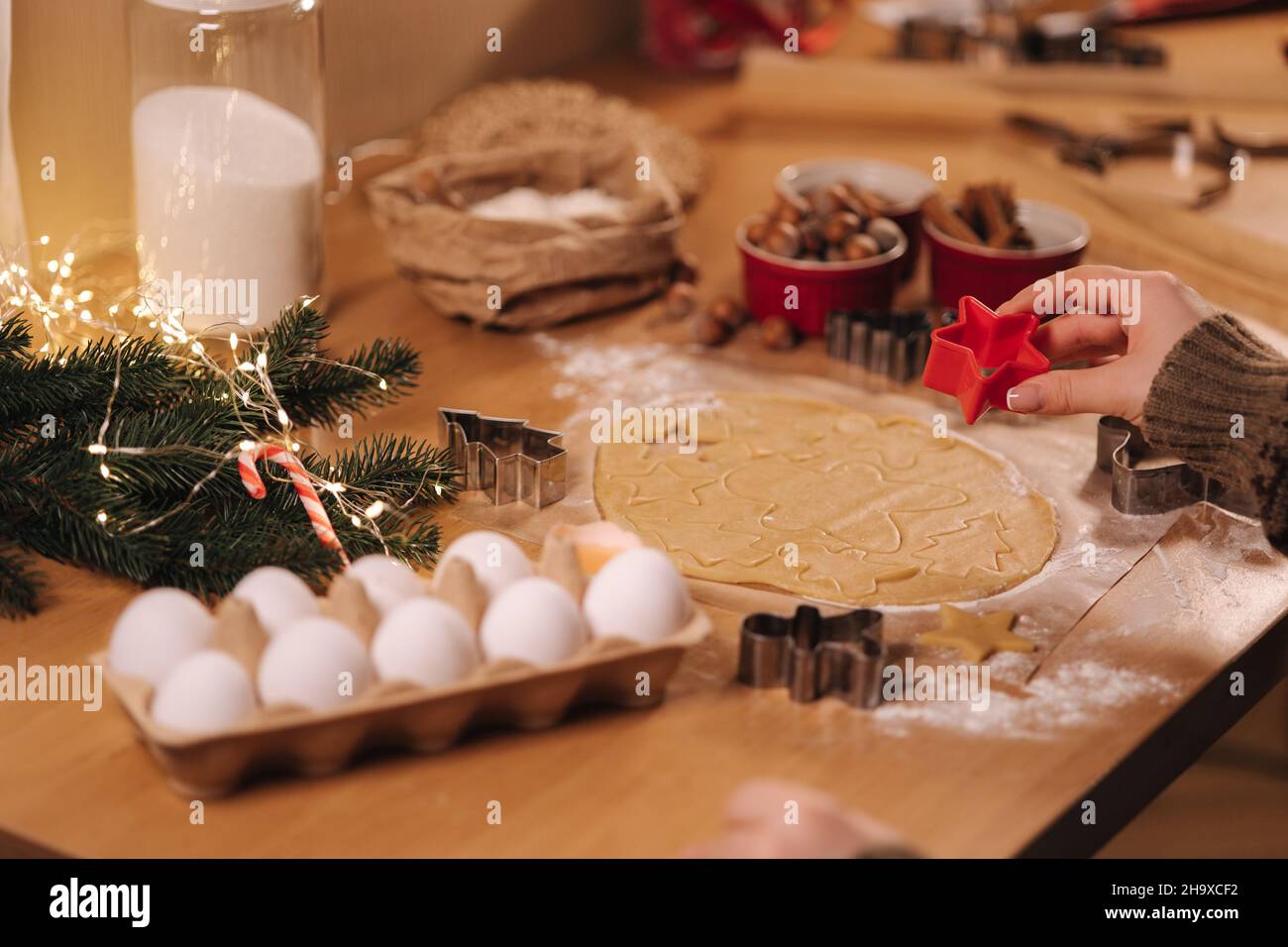 Woman making gingerbread at home. Female cutting cookies of gingerbread ...