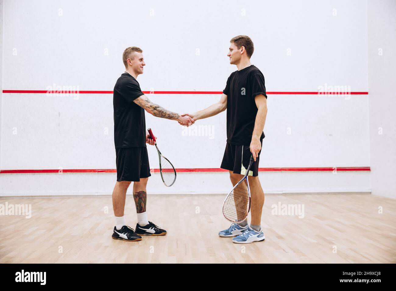 Full-length portrait of two young sportive boys shaking hands after ...
