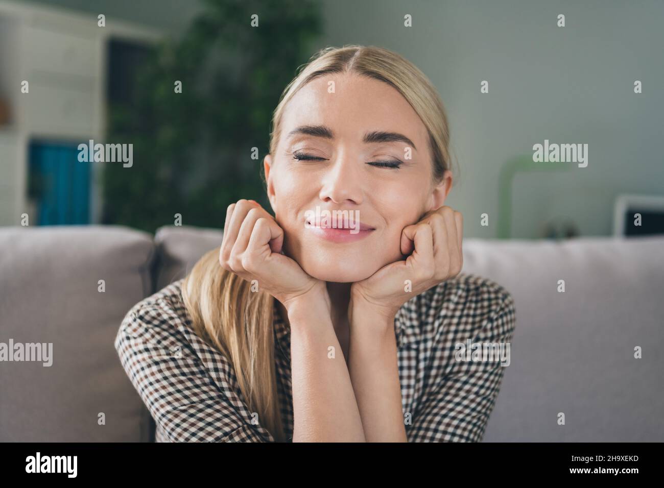 Portrait of charming lovely lady sit comfy divan touch hand chin enjoy holiday vacation in house ...