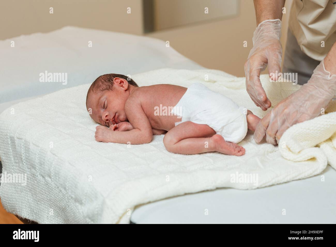 Physiotherapist performing a pro-decubitus roll over a newborn baby ...