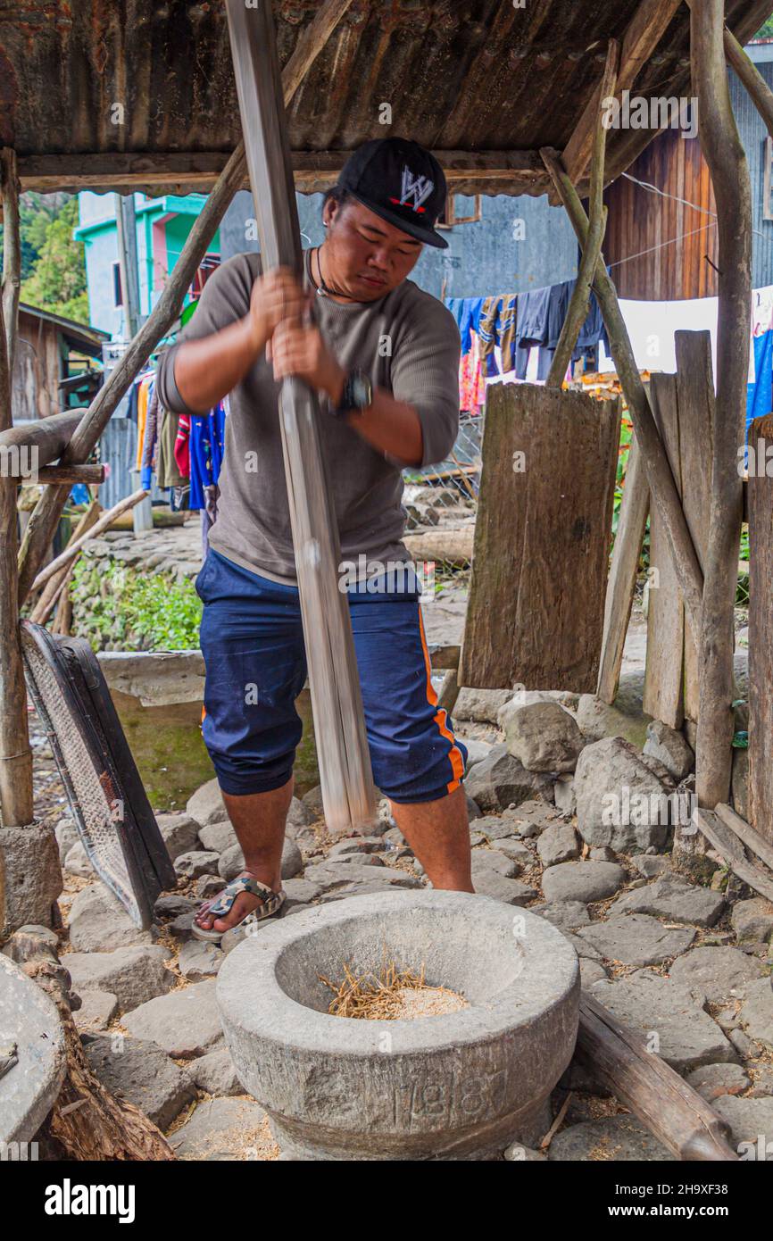 CAMBULO, PHILIPPINES - JANUARY 22, 2018: Local man pounding rice in ...
