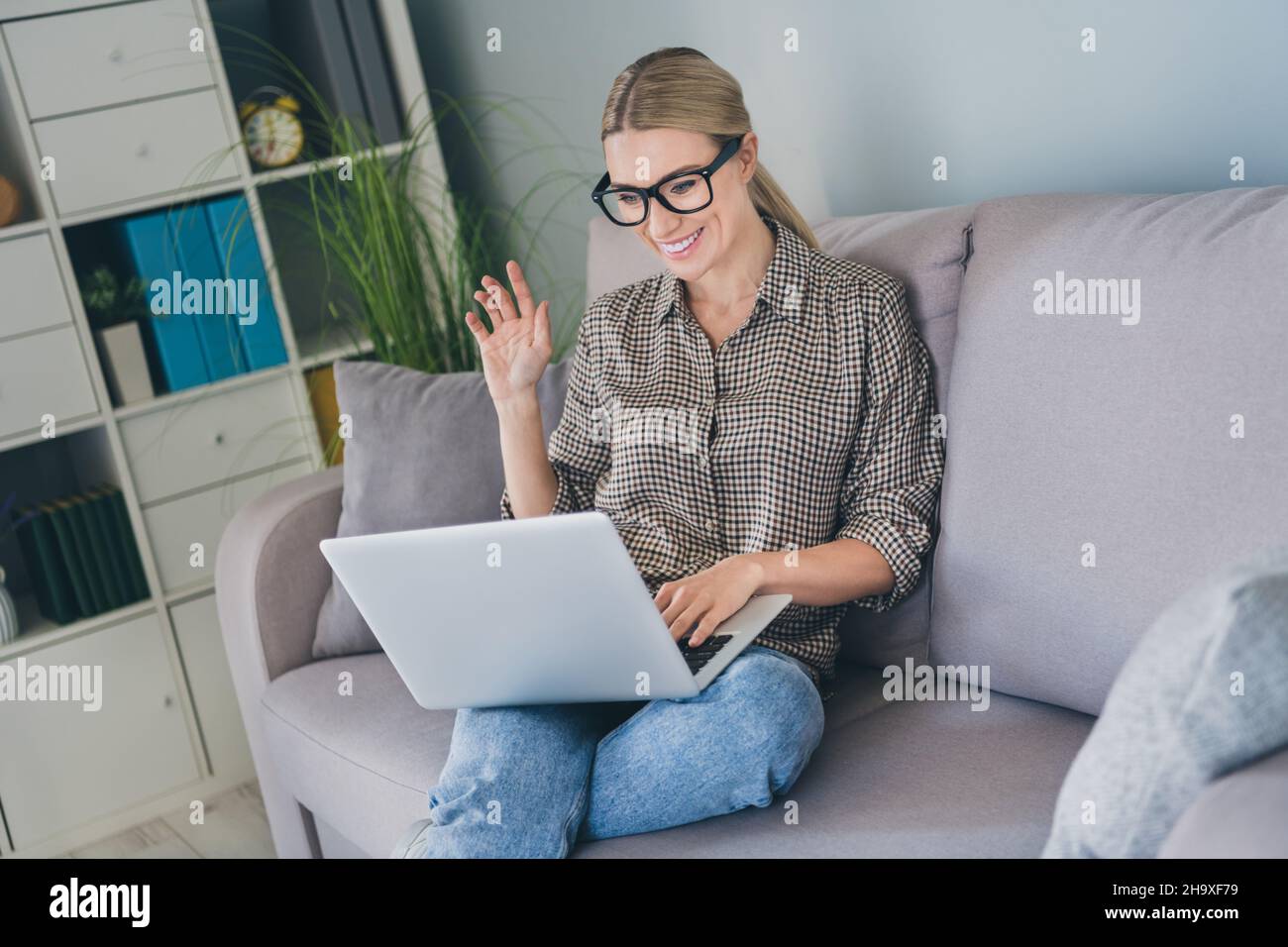 Photo of confident boss executive lady sit couch use app notebook speak ...