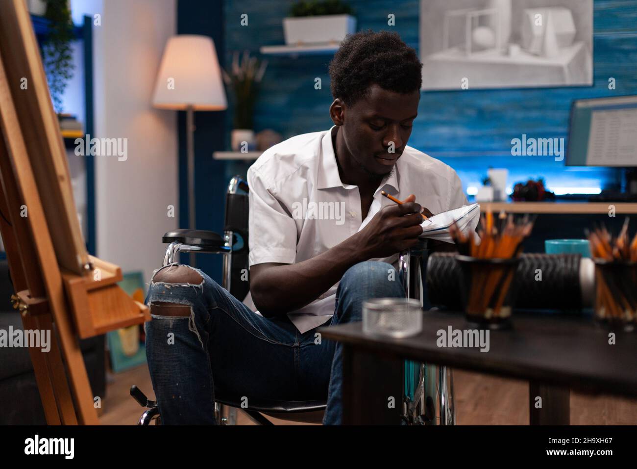 Painter artist with disability drawing sketch on notebook before start ...