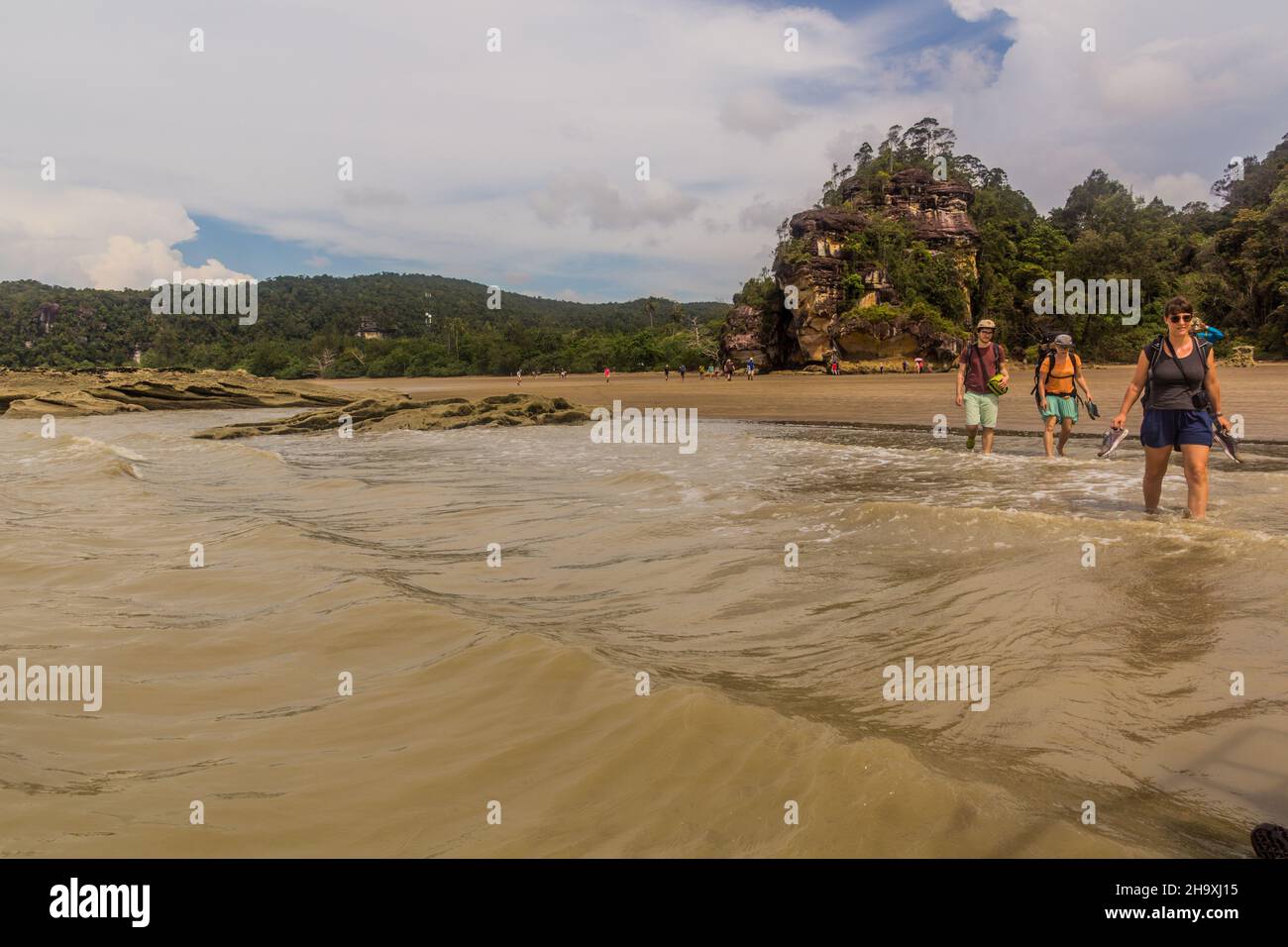 BAKO, MALAYSIA - MARCH 6, 2018: Tourists are wading to a boat in Bako ...