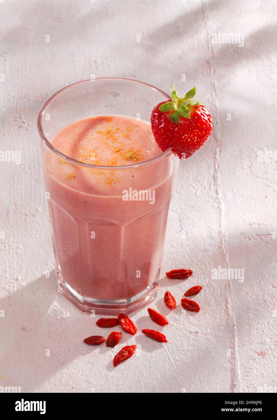 A strawberry and coconut smoothie with coconut milk and goji berries ...
