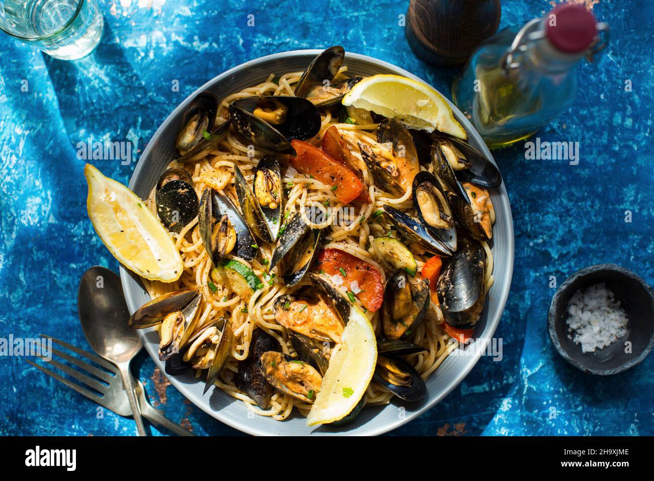 Spaghetti with mussels, zucchini and tomatoes Stock Photo - Alamy