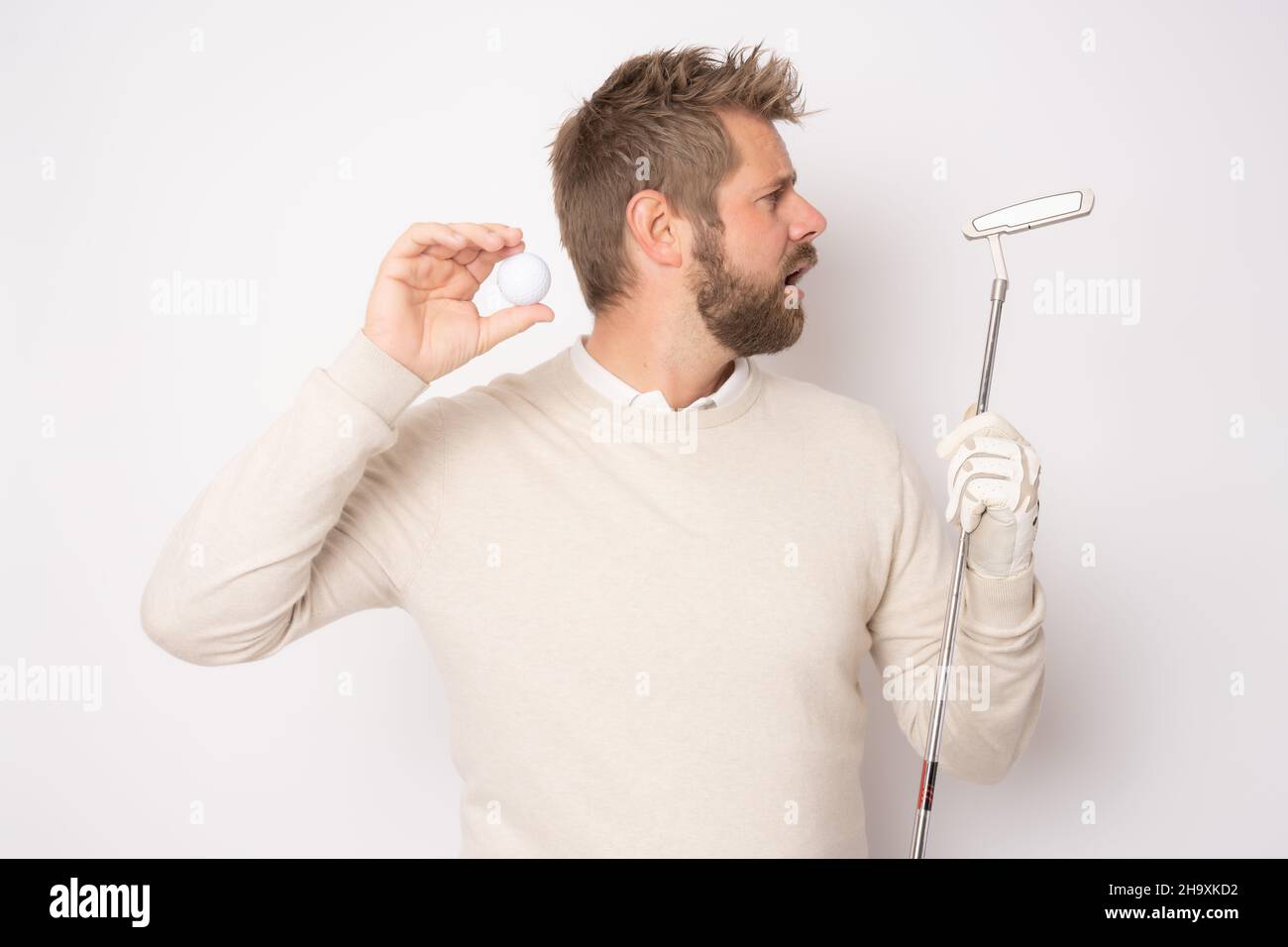 Young handsome man playing golf standing isolated over white background ...