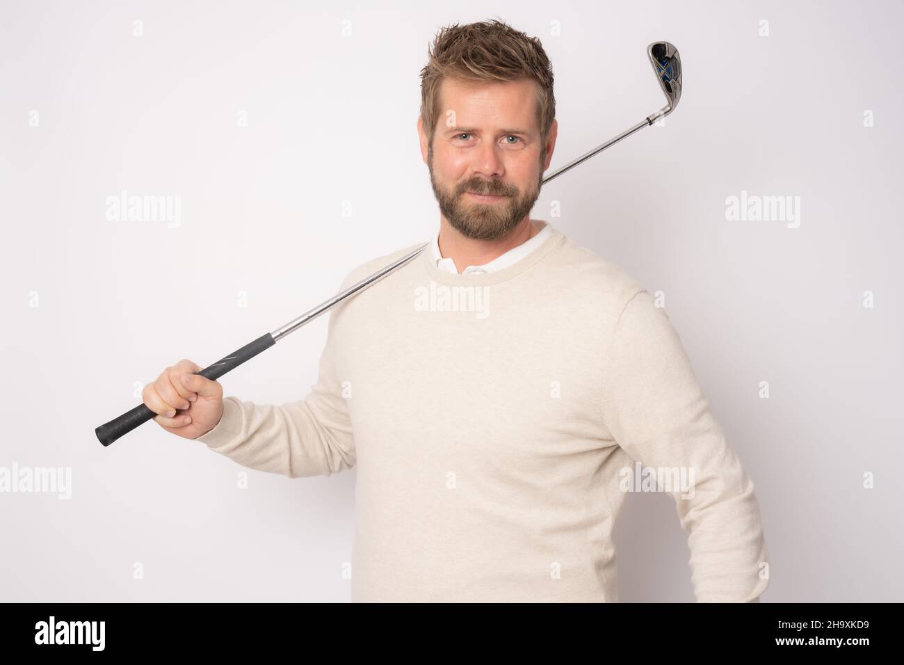 Young handsome man playing golf standing isolated over white background ...