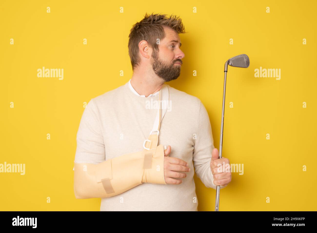 Young golf player man with arm broken with sad expression standing ...