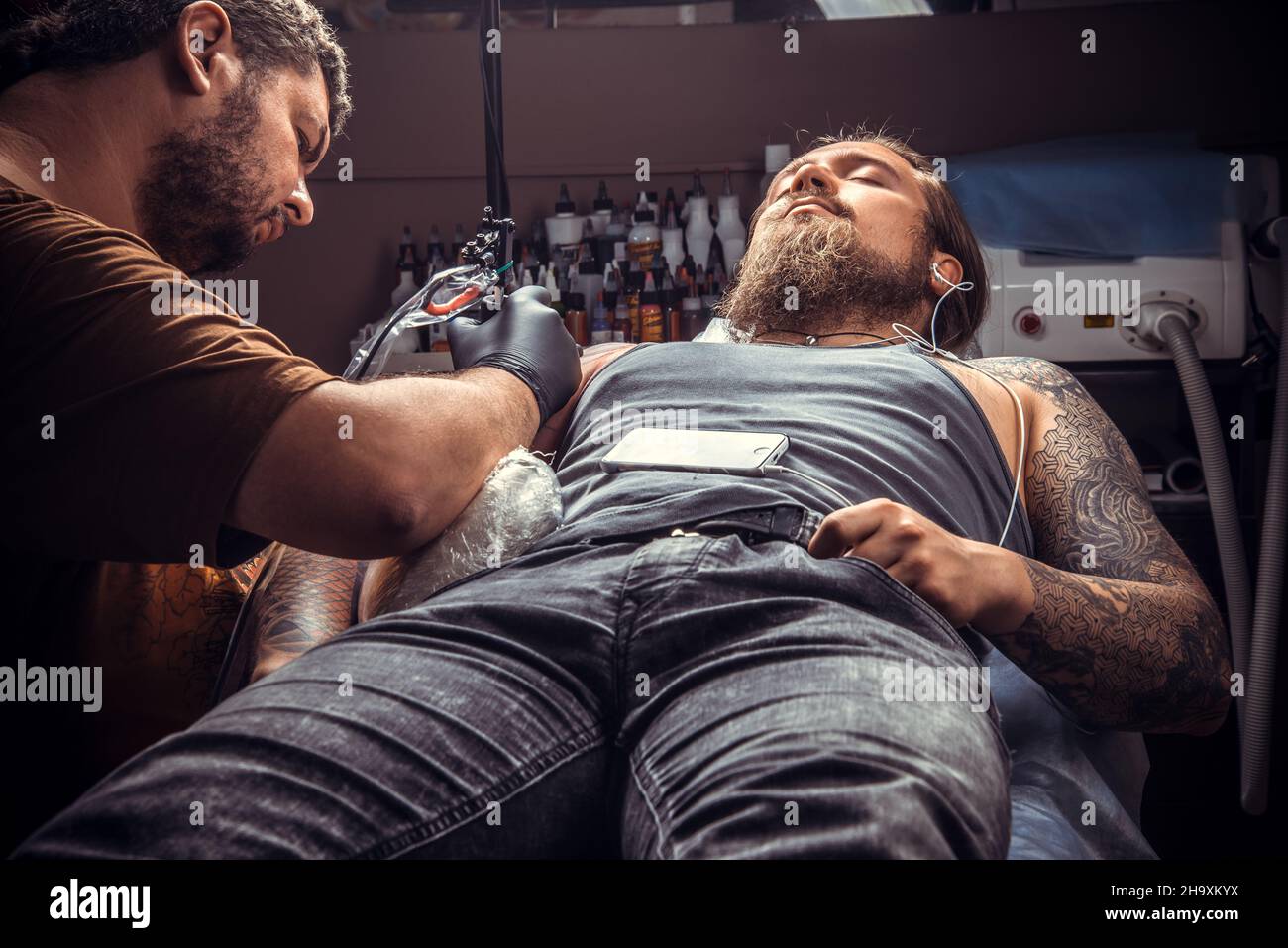 Tattooist makes a tattoo Stock Photo - Alamy