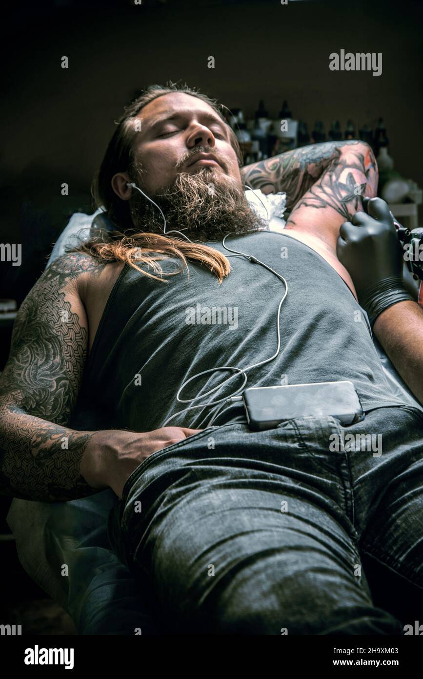 Tattooer doing tattoo in tattoo studio Stock Photo - Alamy