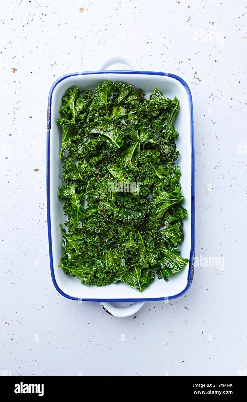 Raw kale with olive oil and spices for kale chips Stock Photo - Alamy