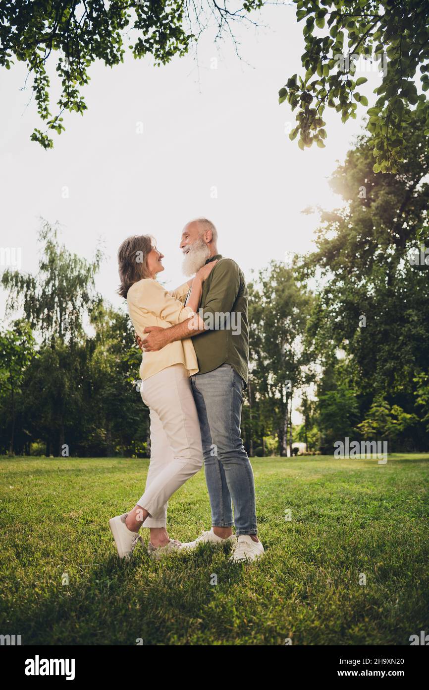 Photo of positive charming retired couple wear casual clothes walking ...
