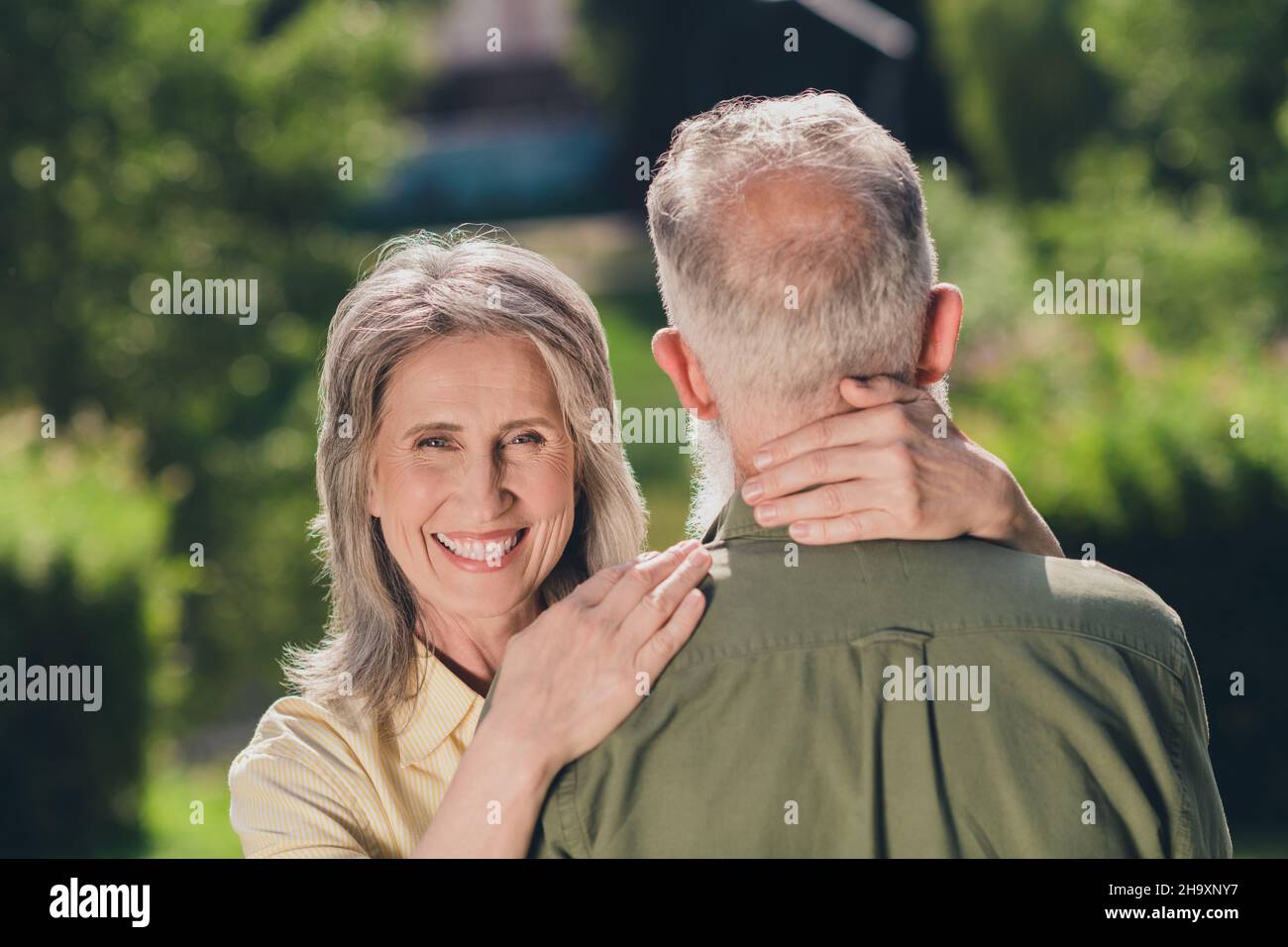 Back side photo of funny old couple hug wear shirt walk in park outside ...