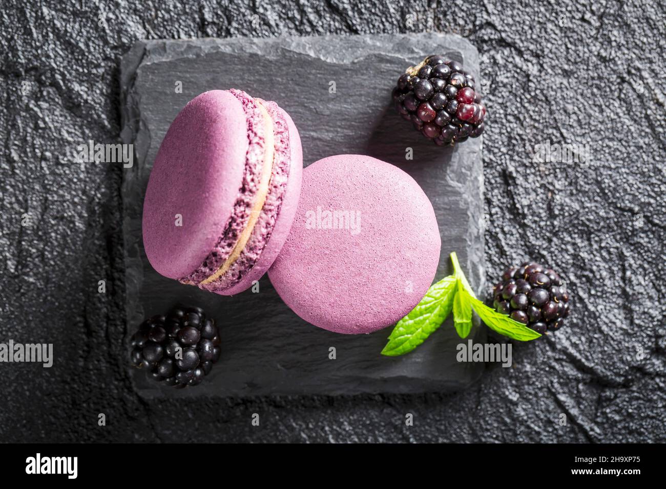 Blackberry macaroons on a black stone Stock Photo - Alamy
