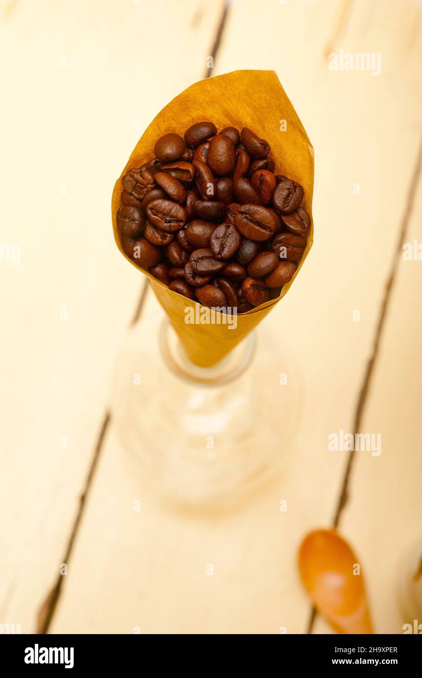 espresso coffee beans on a paper cone cornucopia over white background ...
