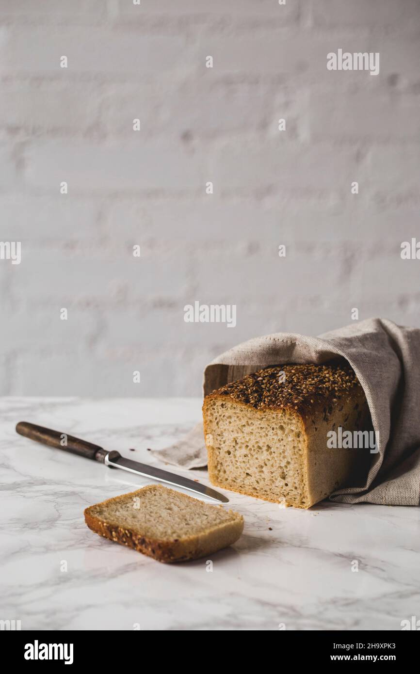A slice load of bread wrapped in a linen cloth on a marble table Stock ...