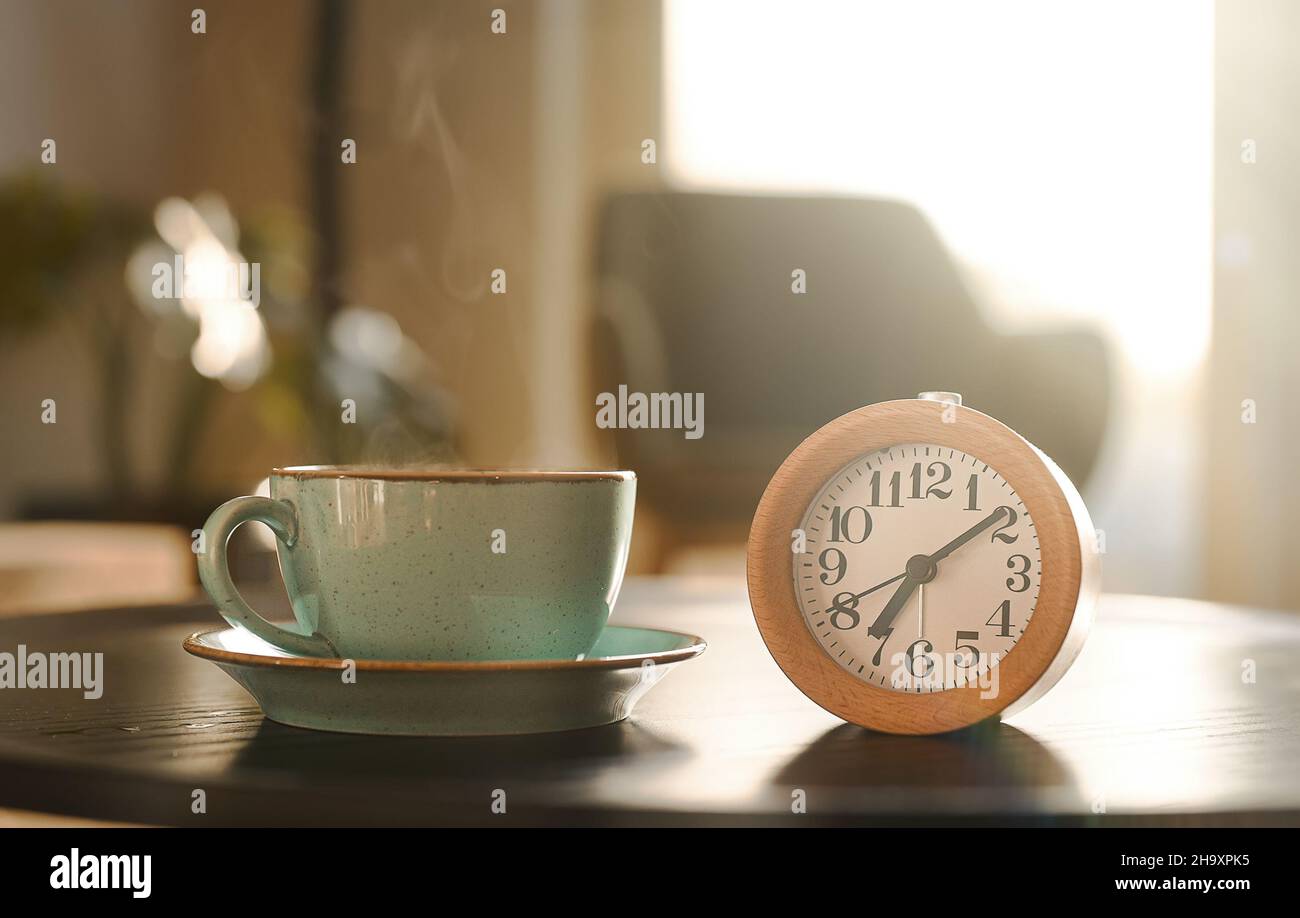 Morning at seven o'clock. Clock and a cup of tea Stock Photo - Alamy