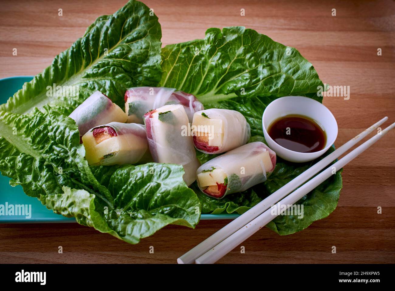 Asian rice paper rolls with duck, cheese and melon served on lettuce ...