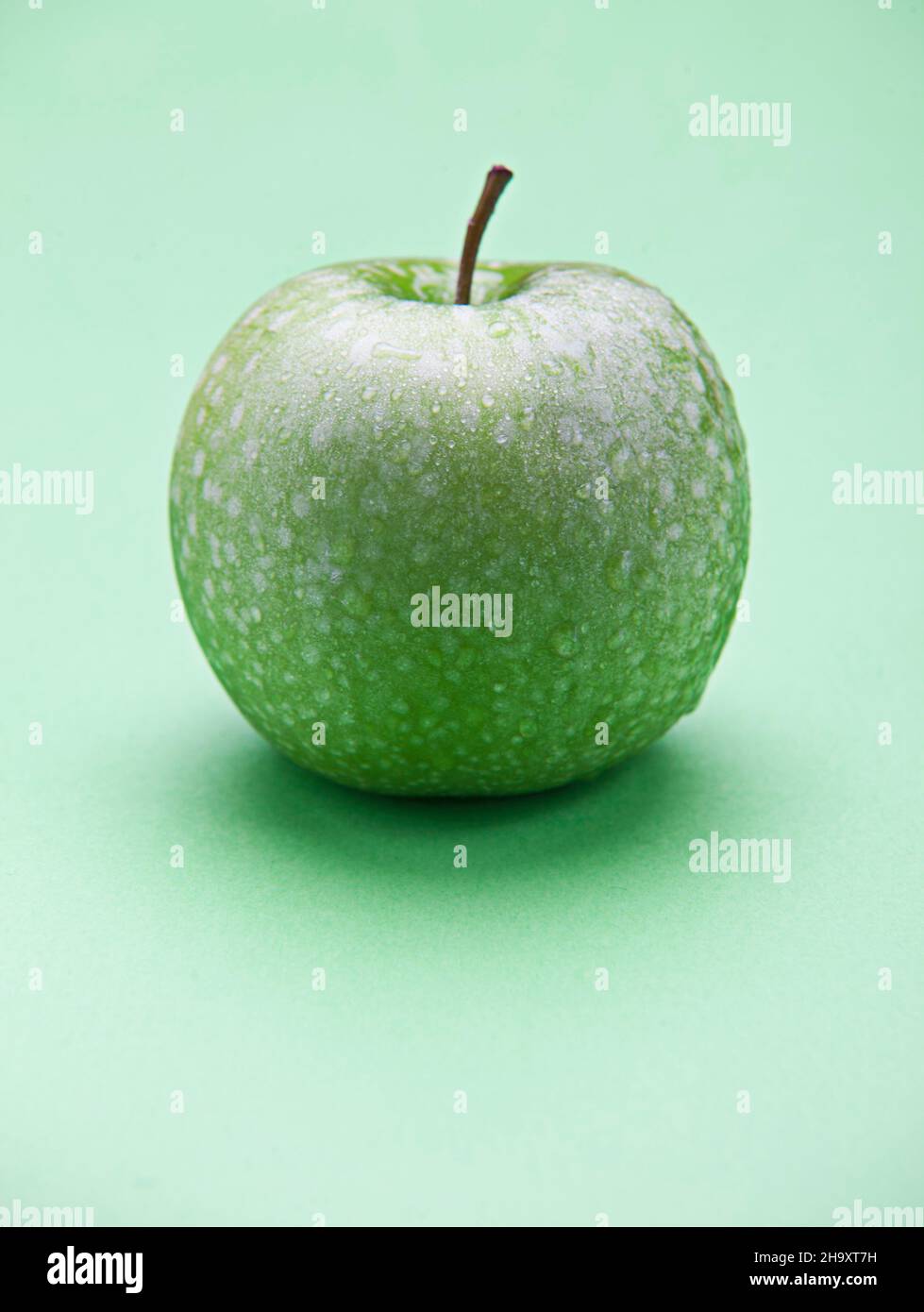 A green apple on a green surface Stock Photo - Alamy