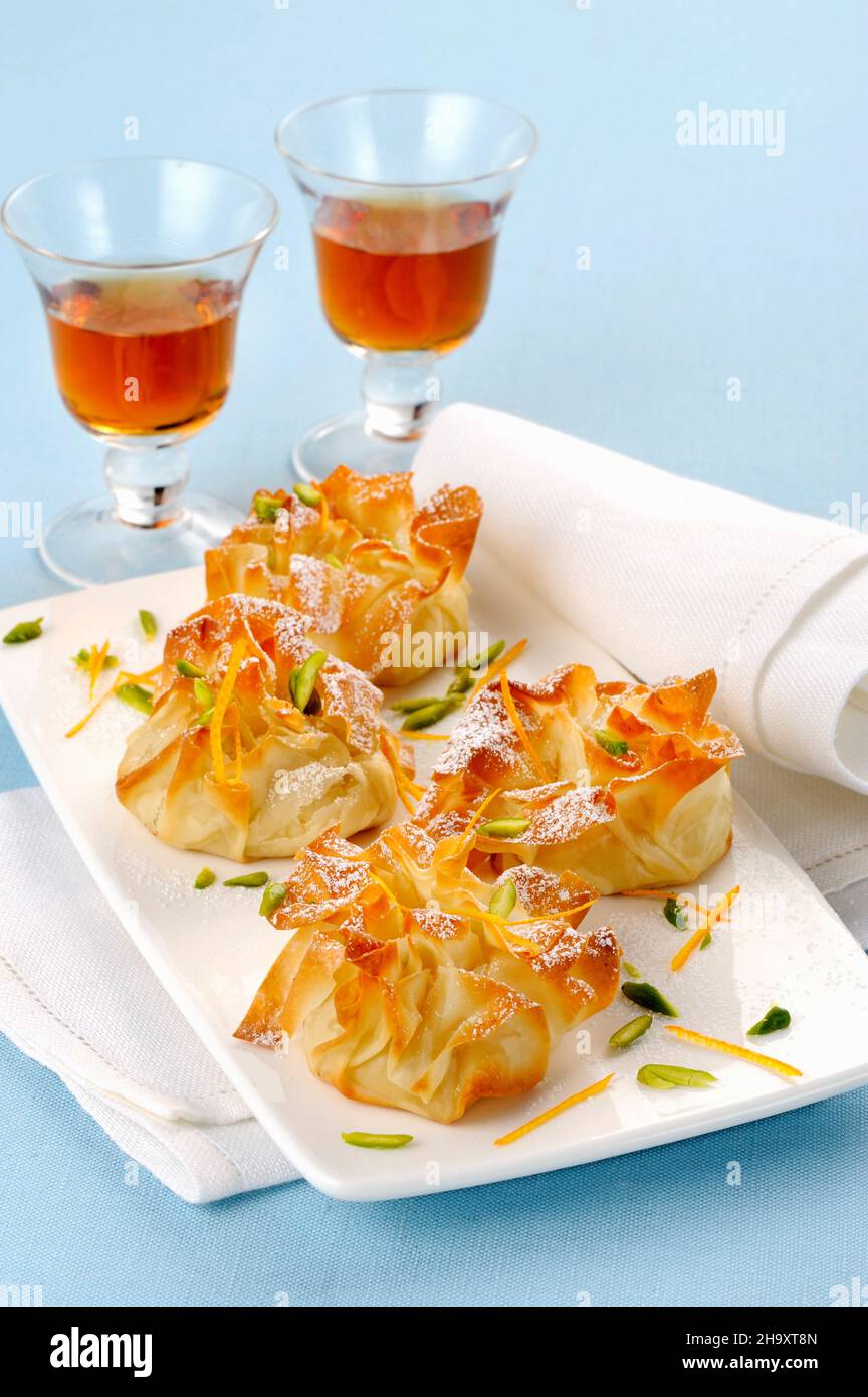 Sweet filo pastry sacks with pistachios and icing sugar served with ...
