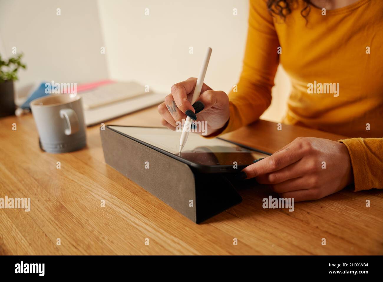 African American female drawing on her digital tablet making notes ...