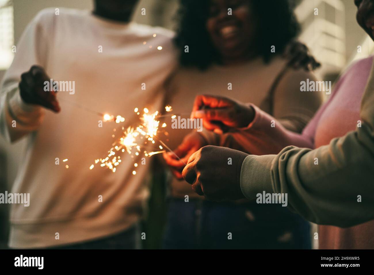 Happy african family using sparklers outdoor at home - Focus on right ...
