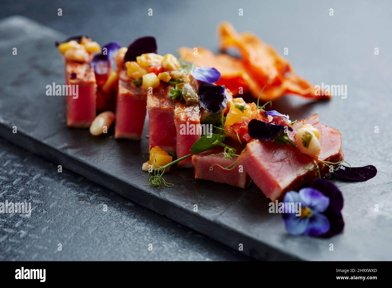 Flash fried tuna on salsa with vegetable crisps Stock Photo - Alamy