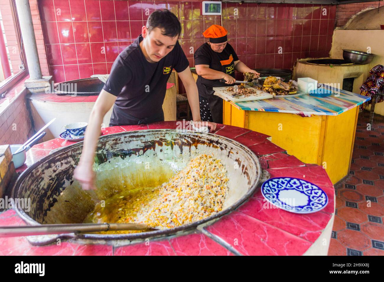 TASHKENT, UZBEKISTAN - MAY 3, 2018: Cooking of plov in the Kazan ...