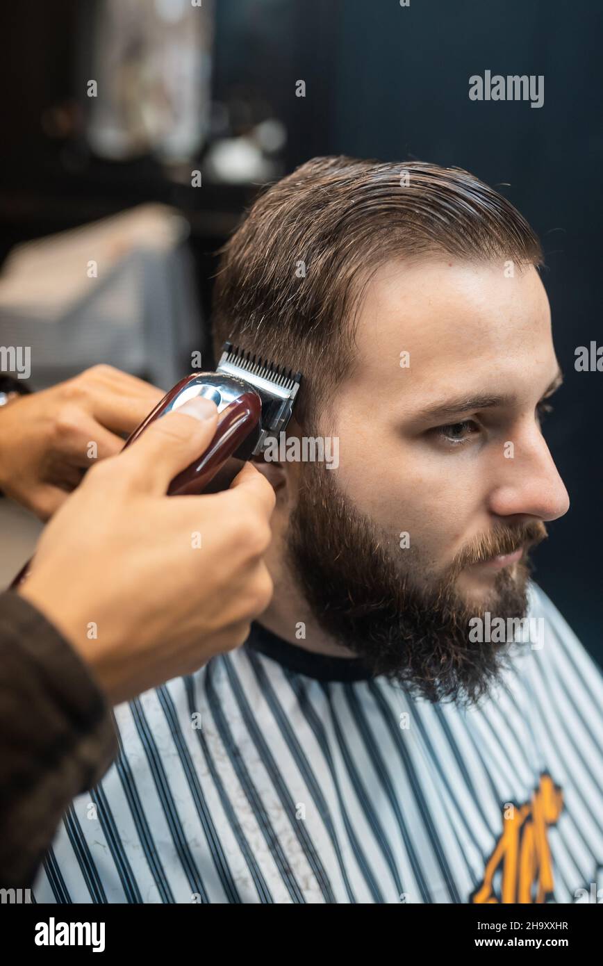 Master in barbershop makes men's haircutting with hair clipper Stock ...