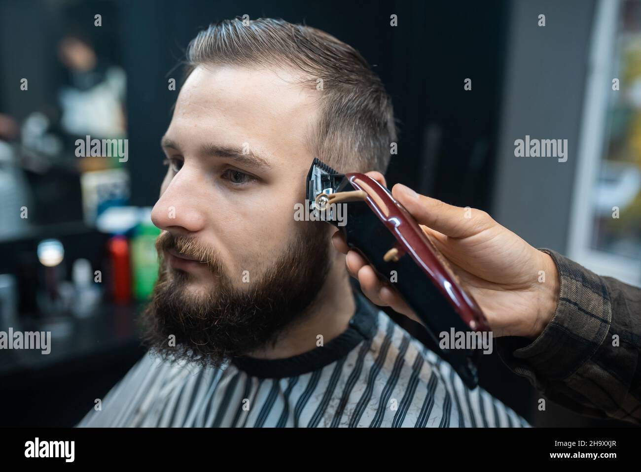 Master in barbershop makes men's haircutting with hair clipper Stock ...