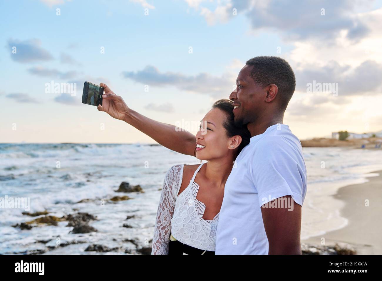 Happy Couple In Love Taking Selfie Together On Smartphone On Beach