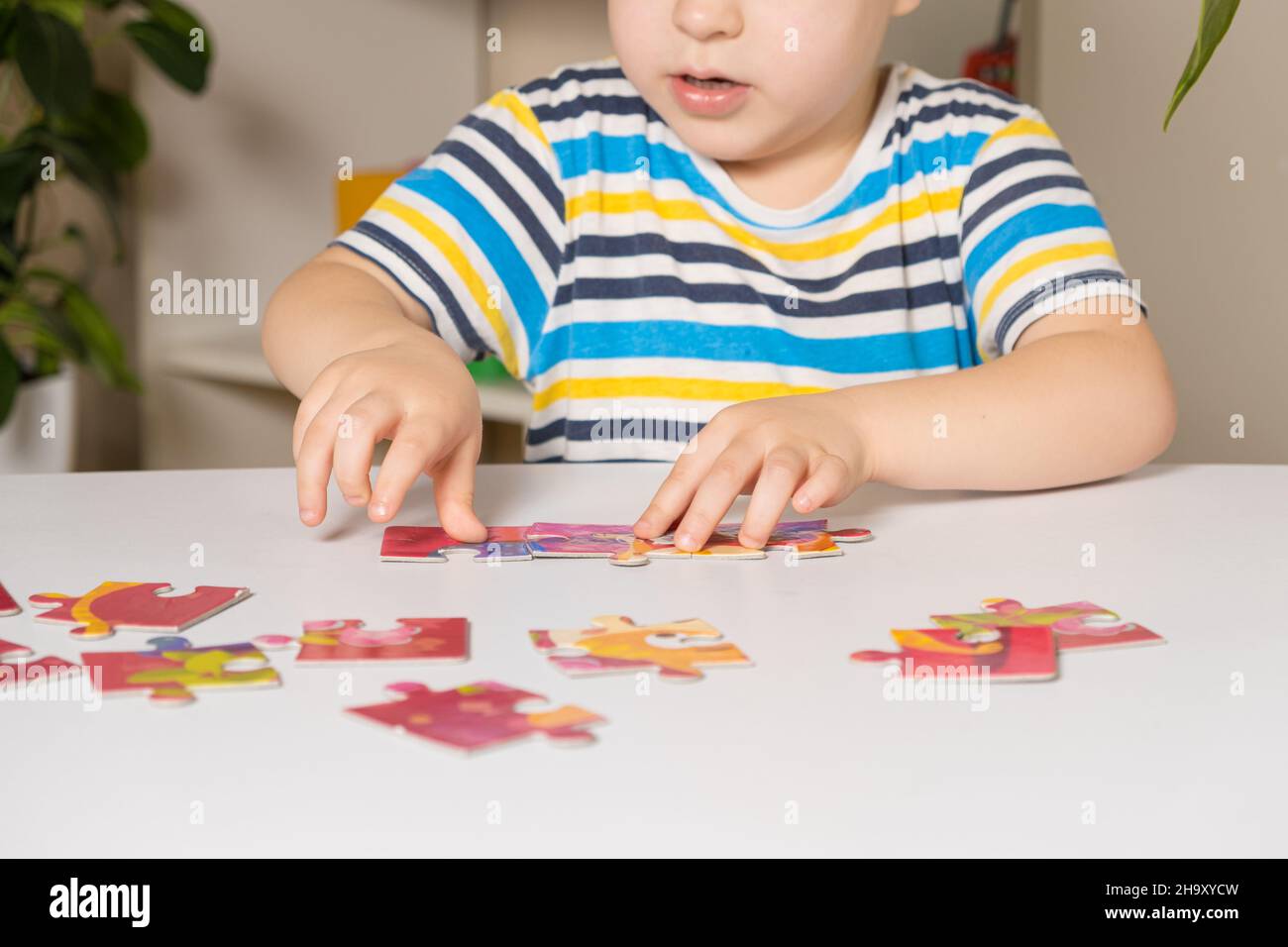Children with hands up at table hi-res stock photography and images - Alamy