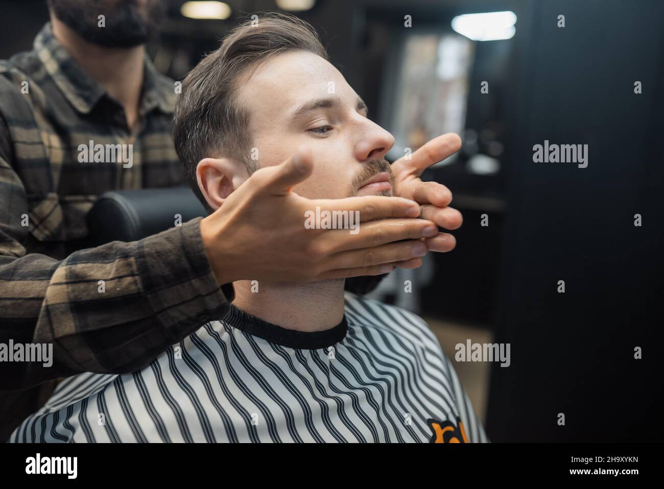 Facial applying lotion after shave in Barber shop Stock Photo - Alamy
