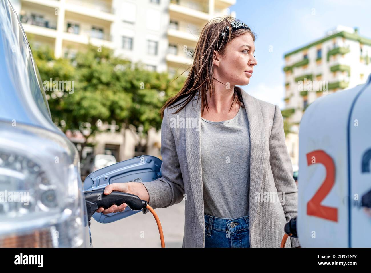 Woman charging an electric car in urban settings, Faro, Portugal Stock ...