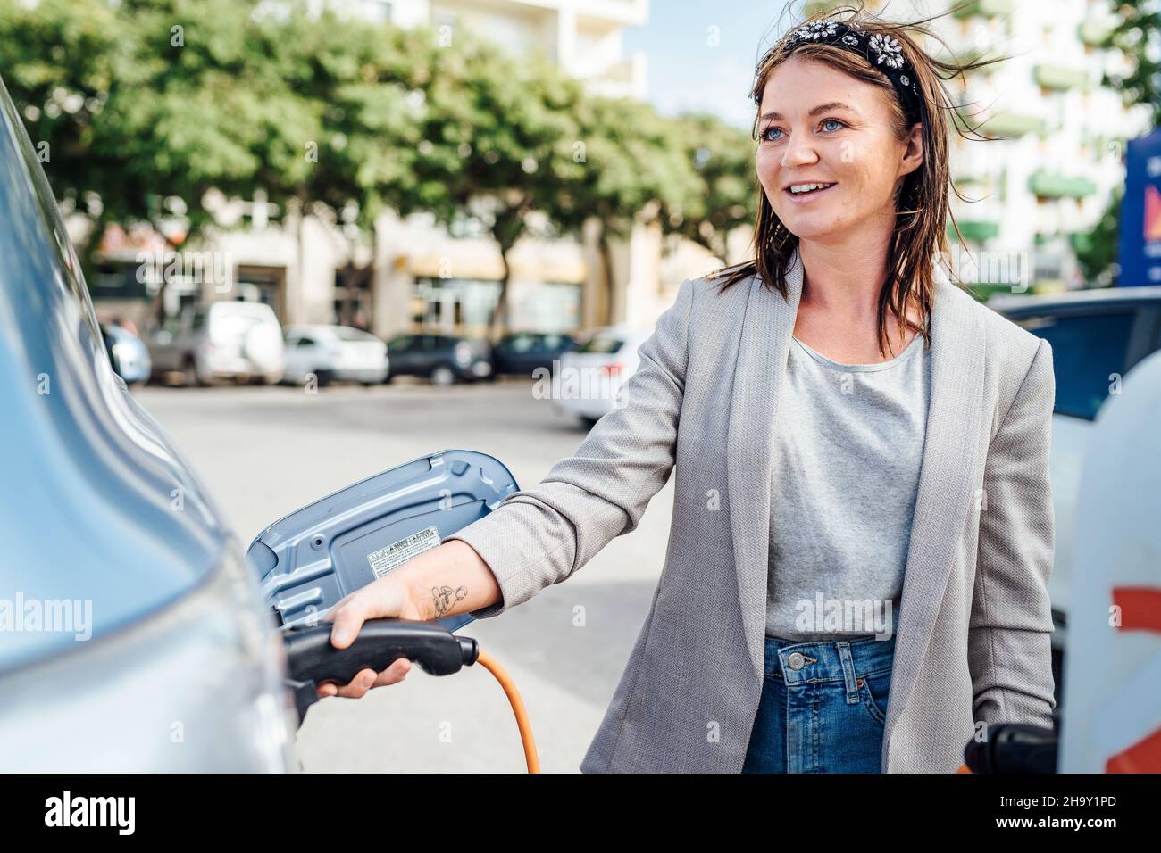 Woman charging an electric car in urban settings, Faro, Portugal Stock ...
