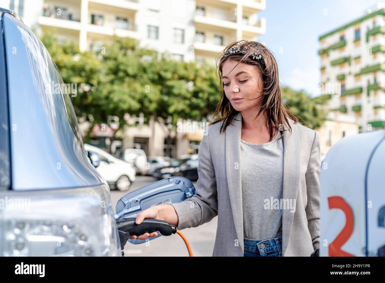 Woman charging an electric car in urban settings, Faro, Portugal Stock ...